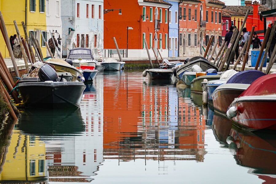 Reflections of Burano colourful houses in canal water Venice Italy