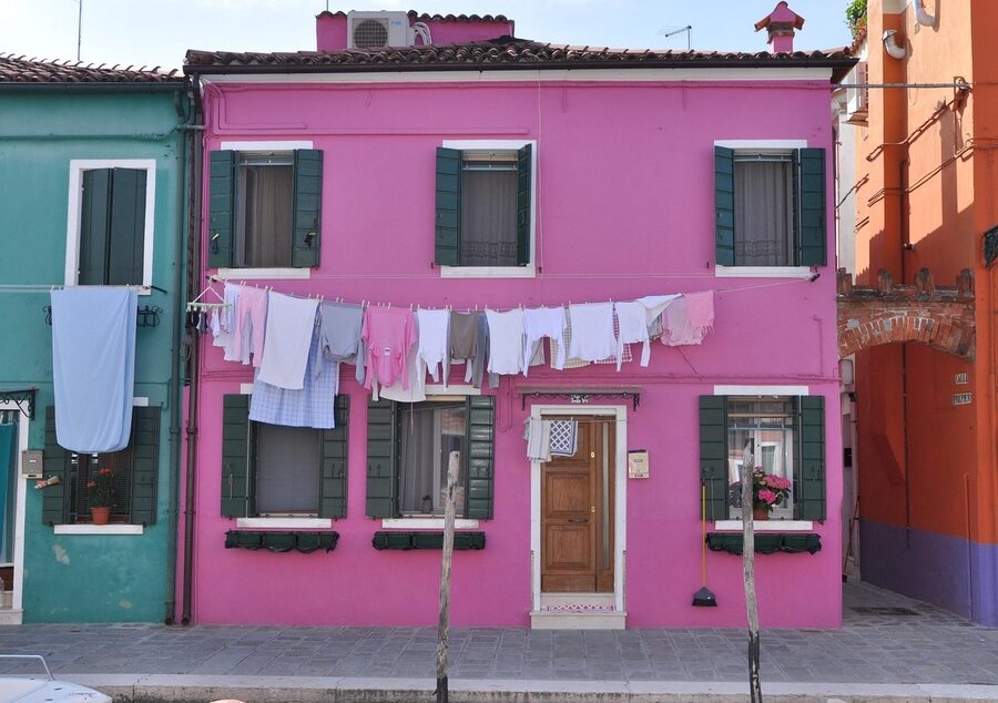 Burano laundry hanging between colourful house facades over a canal