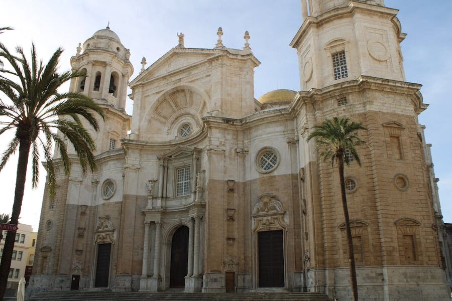 Cadiz Cathedral facade with tall palm trees