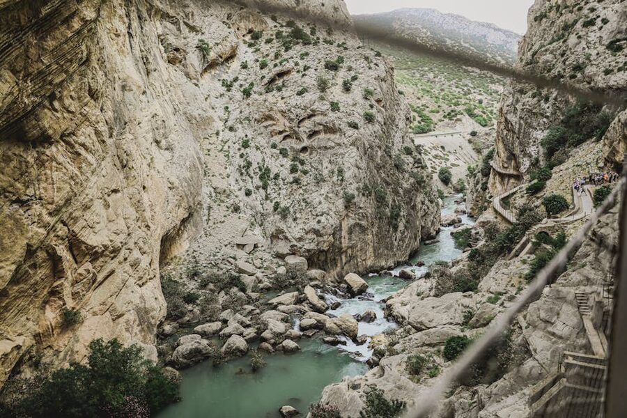 A scenic view of the Caminito del Rey canyon with hikers and the river