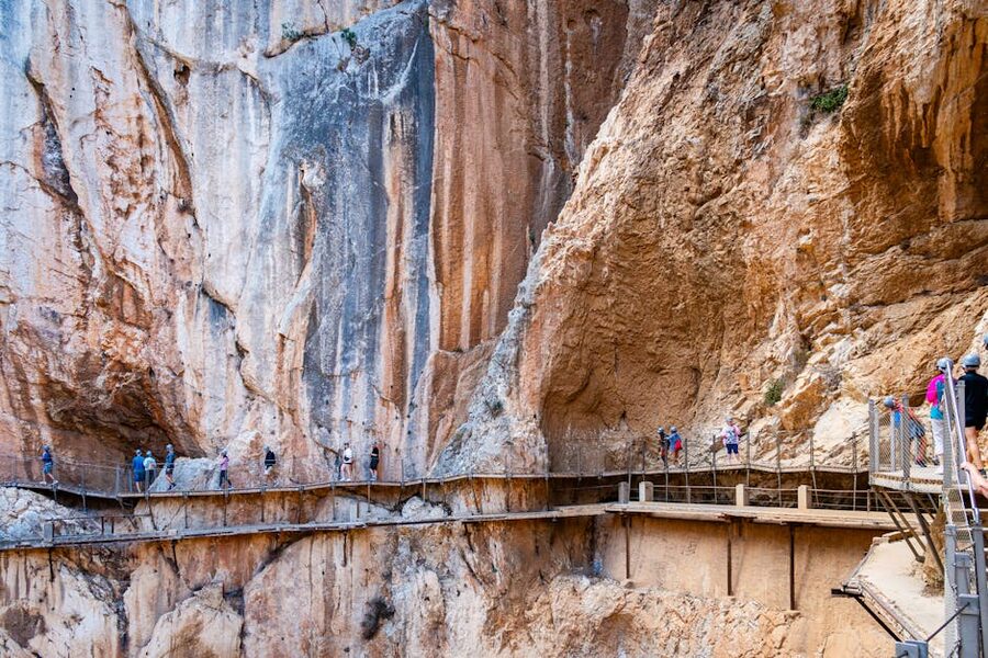 Hikers on the Caminito del Rey walkway above the El Chorro gorge