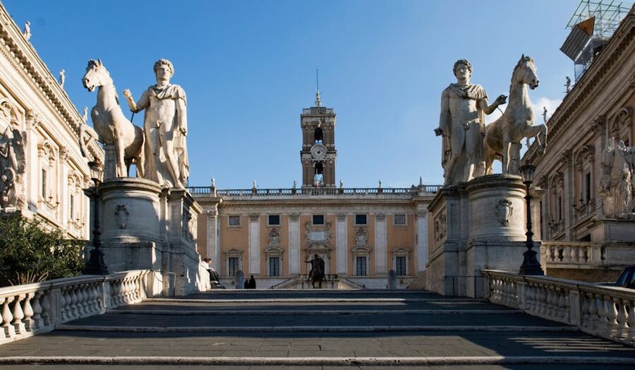 Statues at Capitoline Hill with Renaissance architecture in the sunlight
