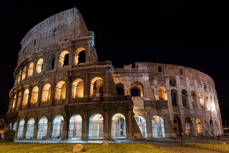The Colosseum lit at night with warm floodlights