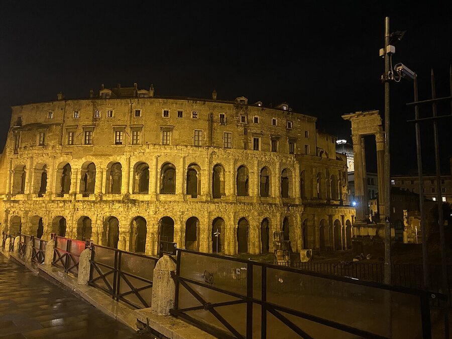 The Colosseum in Rome lit up at night against a dark sky