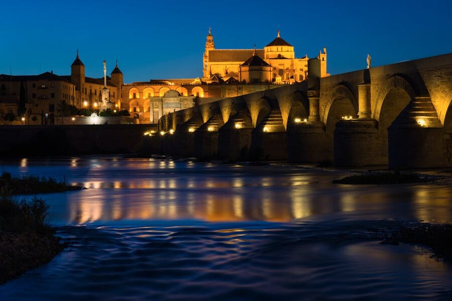 Roman bridge and Mezquita illuminated at night Cordoba