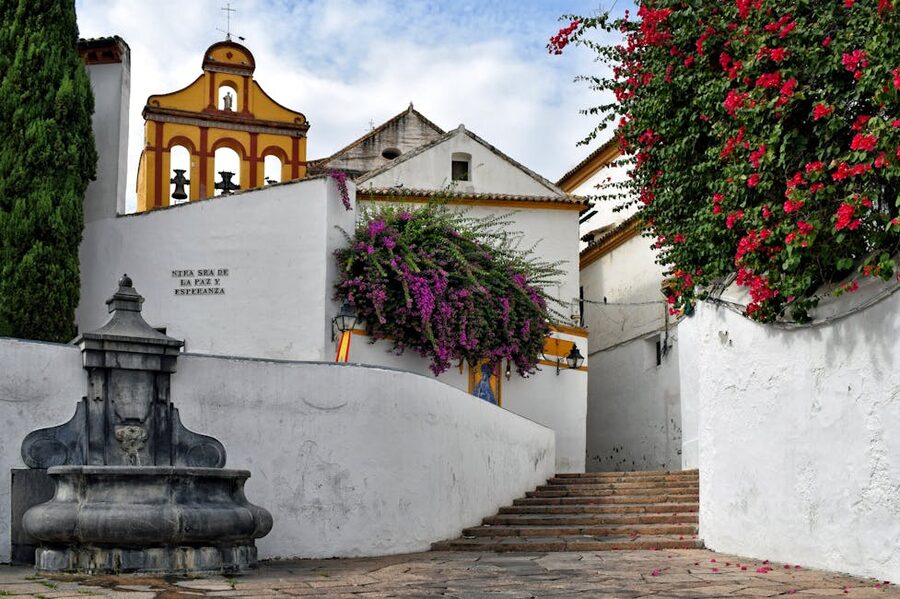 Alley in Cordoba with bell tower and bougainvillea