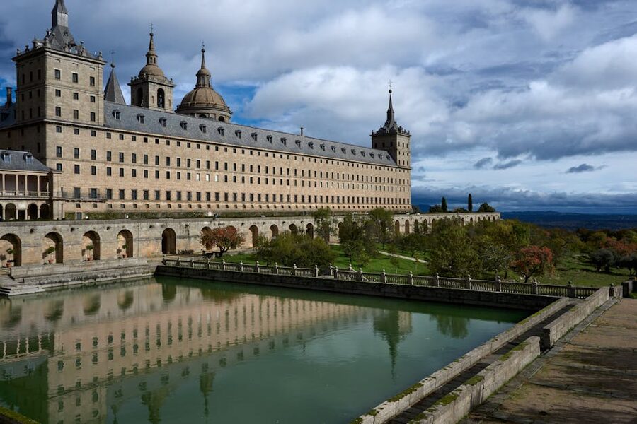 El Escorial Monastery reflected in a pond on a cloudy day