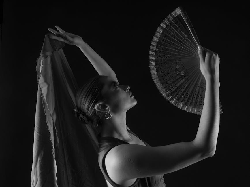 Black and white flamenco dancer with fan in graceful poised stance