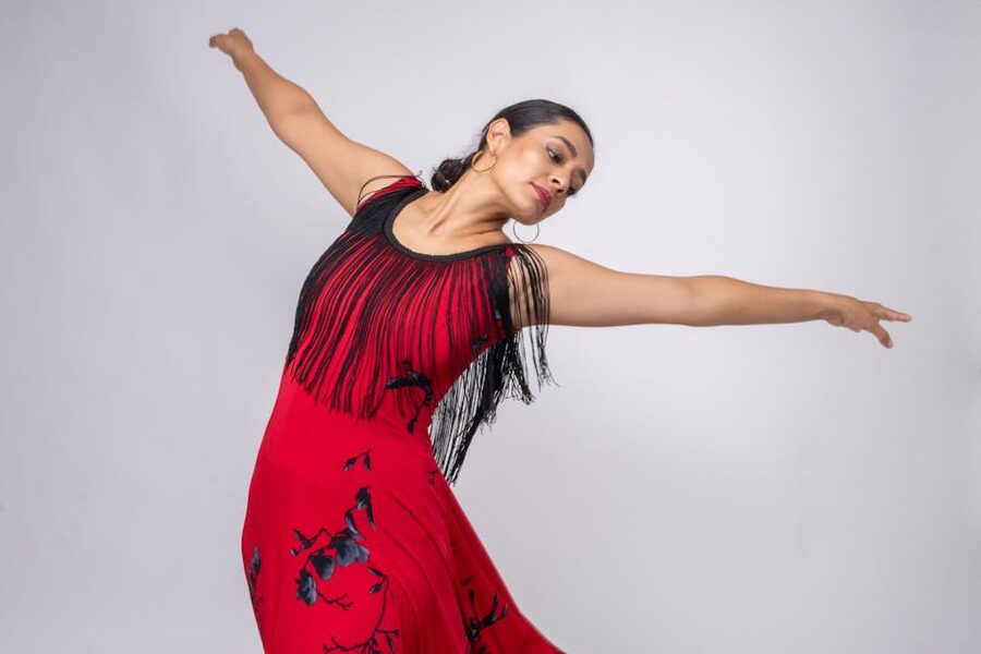 Flamenco dancer in red dress mid-spin in a Madrid tablao show
