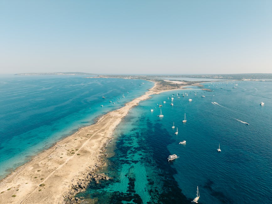 Aerial view of Formentera turquoise coastline with sailboats