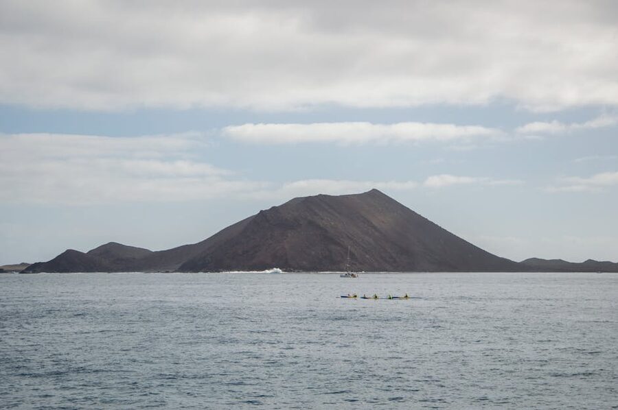 Kayakers near a volcanic island in Corralejo