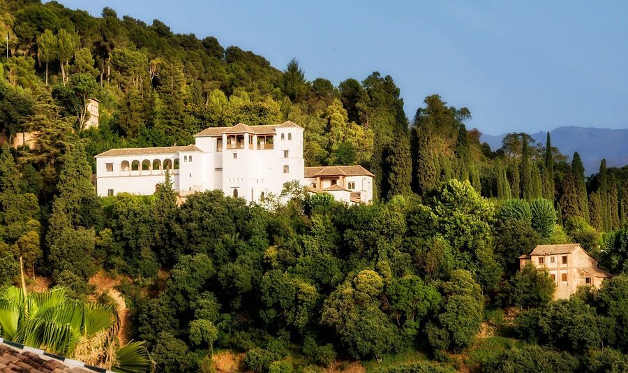 Generalife palace exterior with mountains and forest