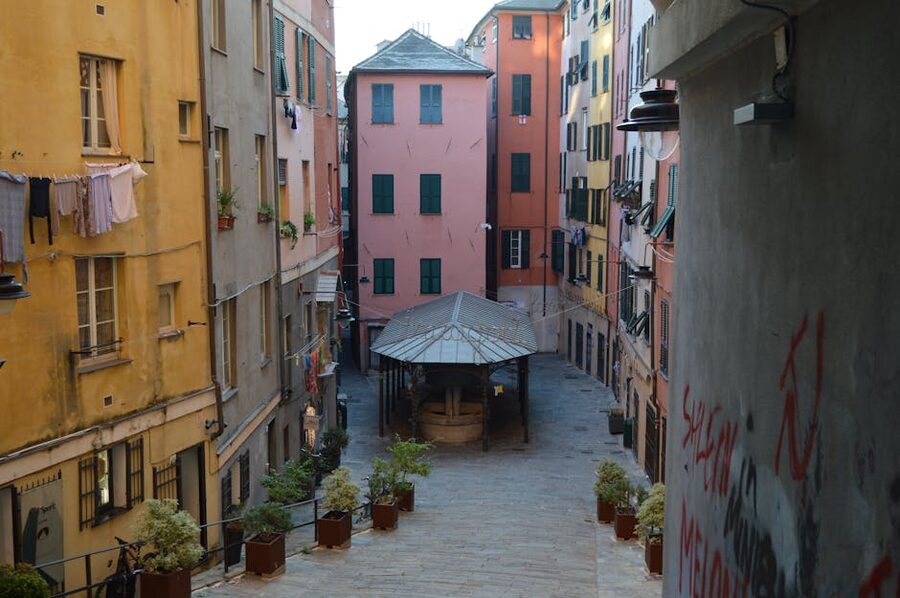 Narrow caruggi alley in Genoa with colourful buildings and hanging laundry