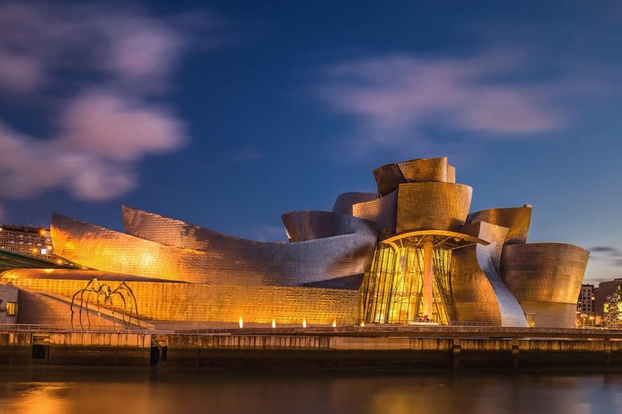 Guggenheim Bilbao illuminated at evening with reflection