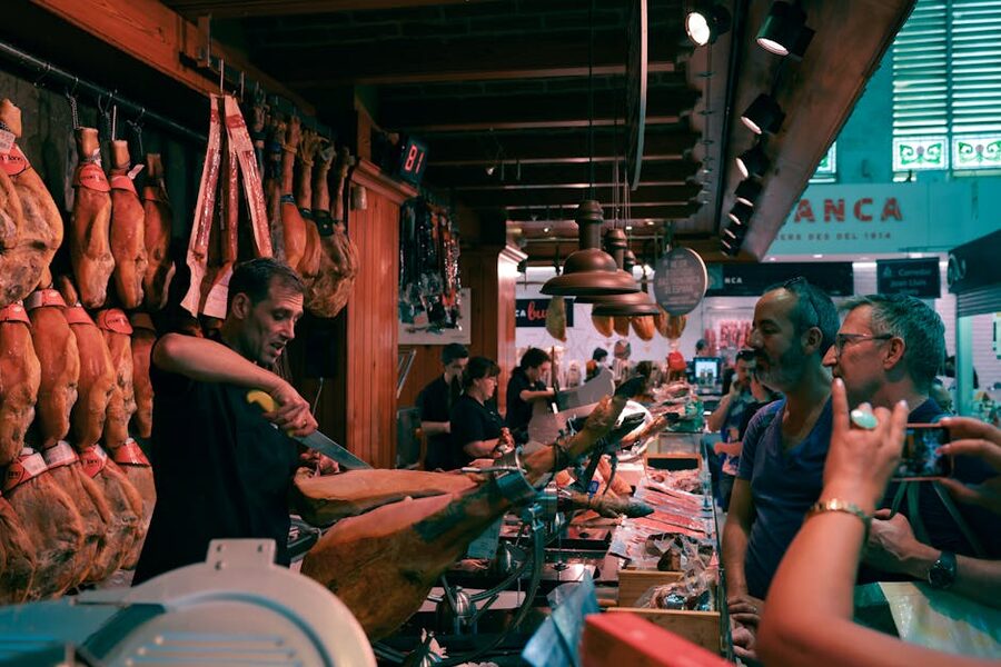 Barcelona market butcher slicing Spanish jamón by hand