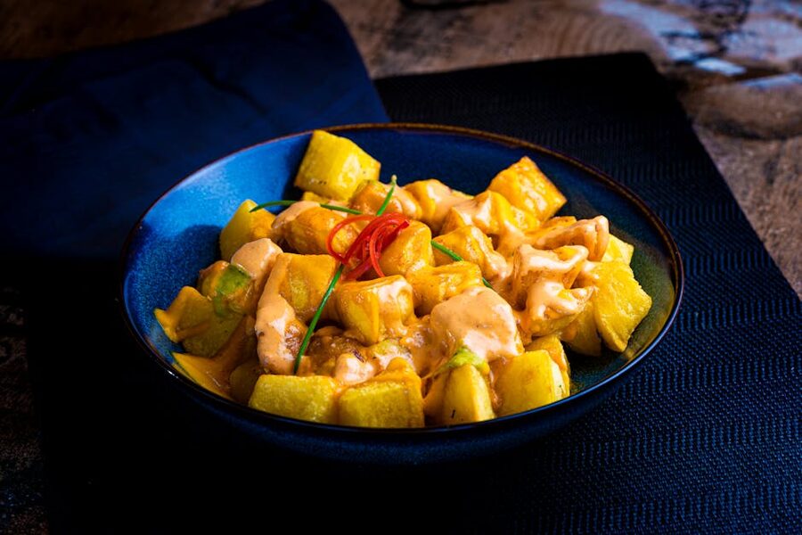Patatas bravas with spicy aioli in a blue bowl
