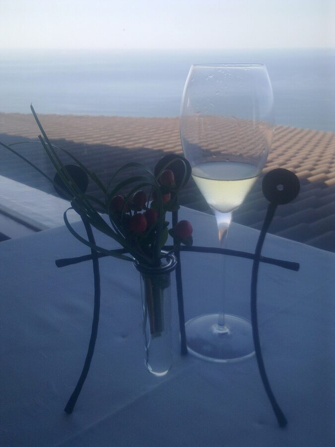 Glass of txakoli being poured from height