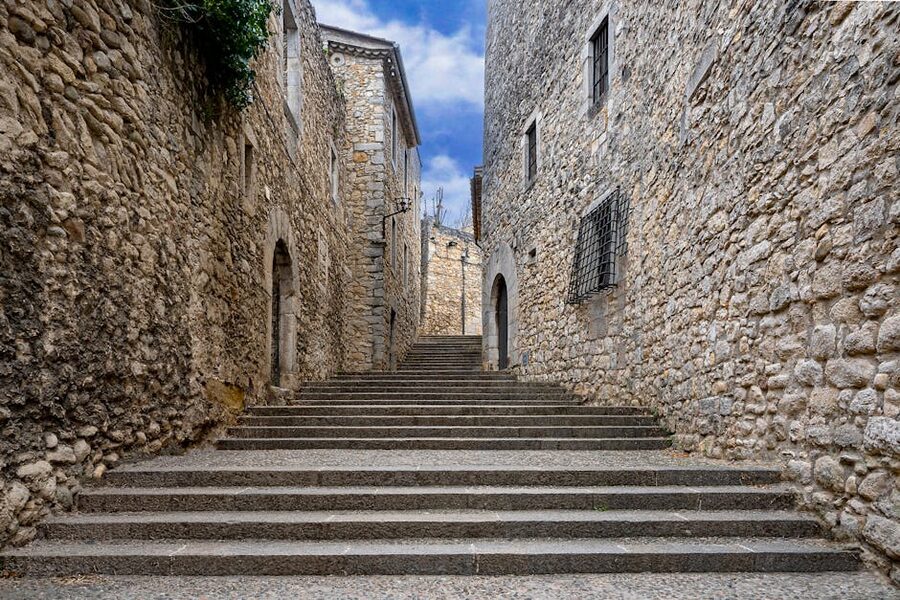 Stone steps in a medieval alleyway between Gothic buildings in Girona