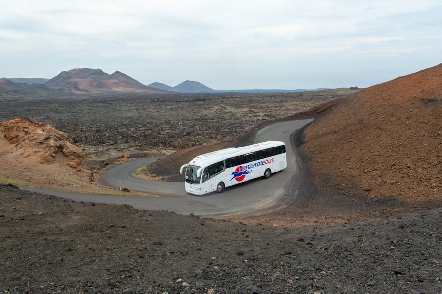 Tour coach bus on the volcanic road through Timanfaya