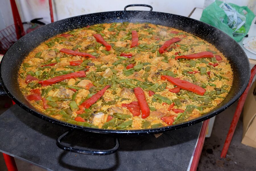 Large cauldron of paella cooking outdoors