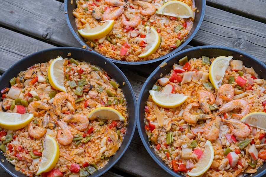 Three paella pans served on a wooden table