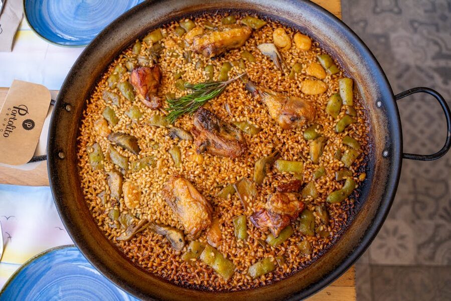 Authentic paella valenciana with chicken and rosemary