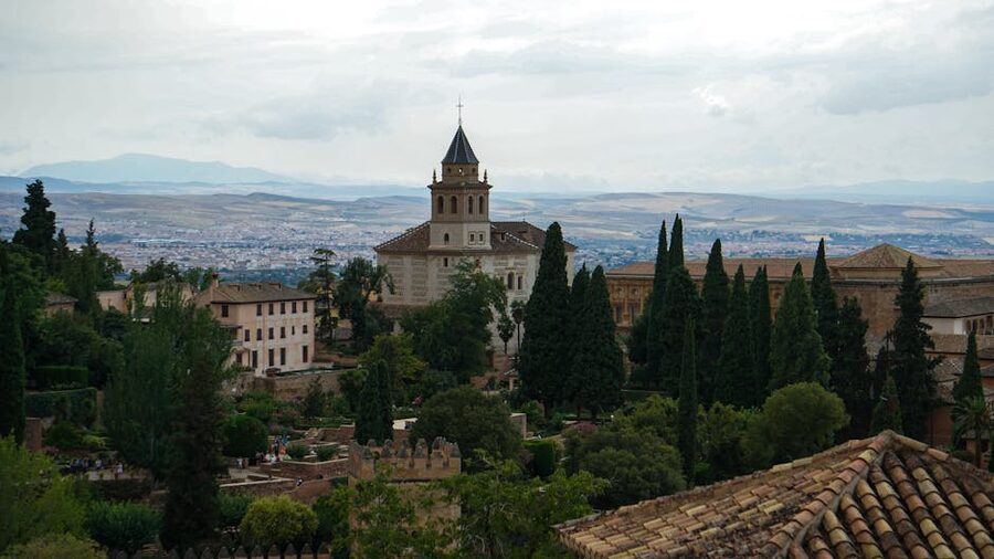 Alhambra distant hilltop view through trees Granada