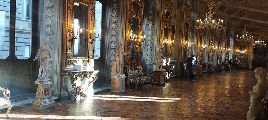 Long gallery hung floor to ceiling with paintings at Doria Pamphilj