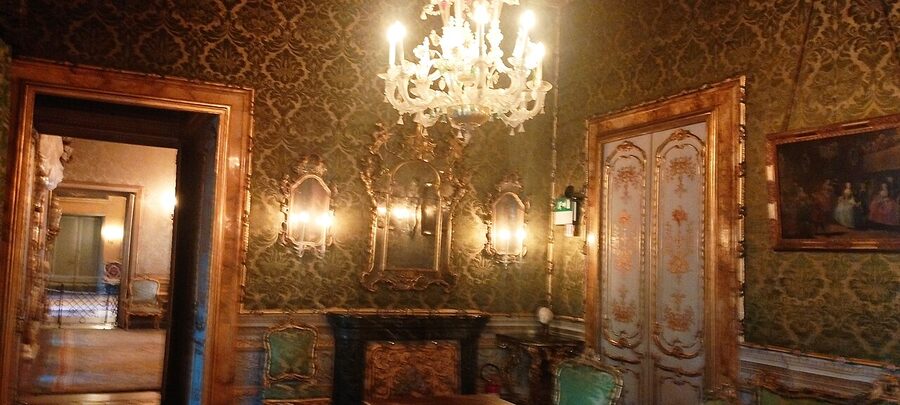 Room hung with paintings on damask walls at Doria Pamphilj