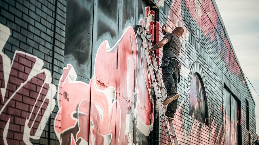 Graffiti artist at work on a brick wall