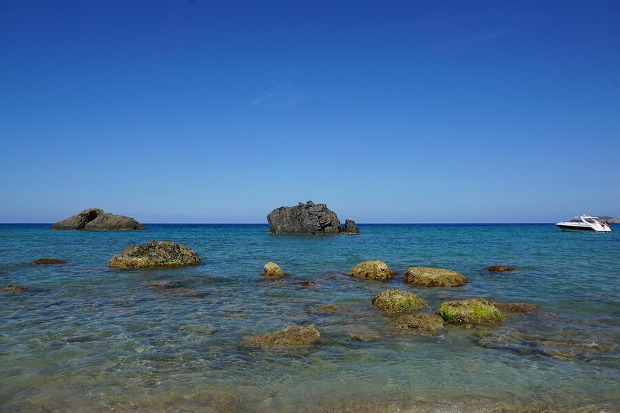 Boat among rocks and stones Ibiza coast