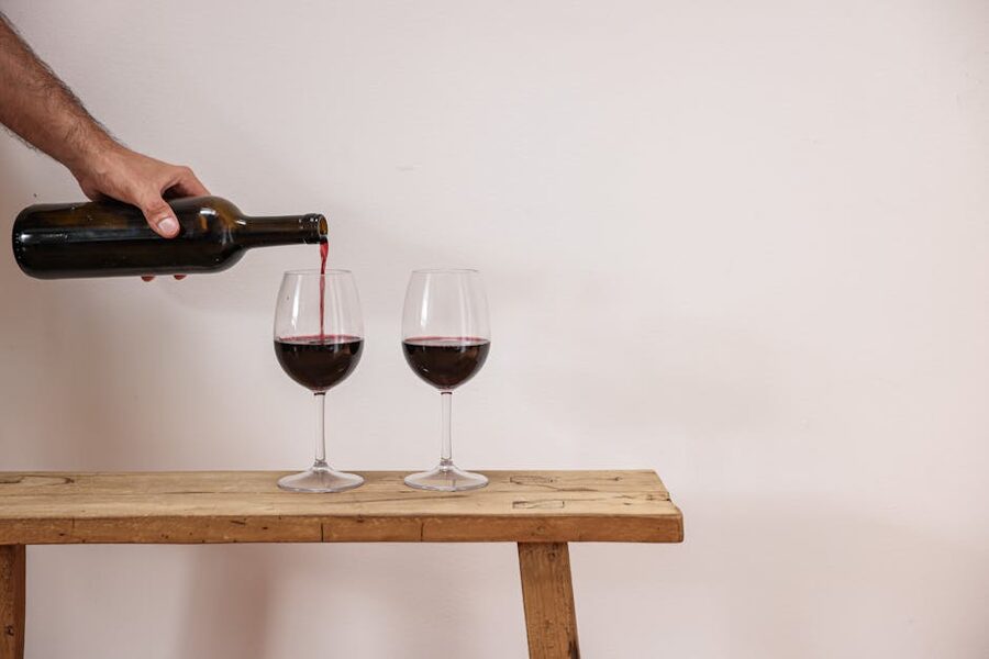 Pouring Italian red wine on a rustic wooden table