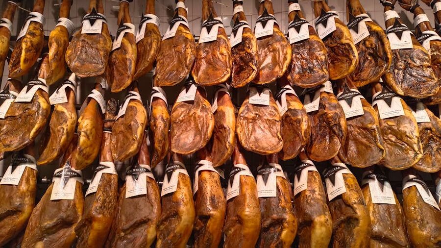 Jamon iberico hams hanging in a Spanish market display
