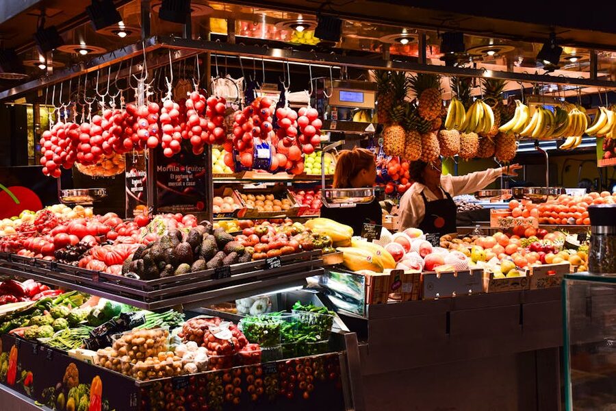 Warm-lit fruit stand at La Boqueria market Barcelona