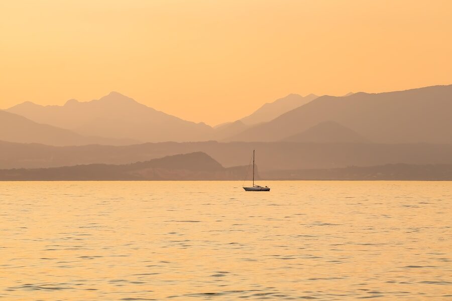 Sailboat in fog at sunset on Lake Garda