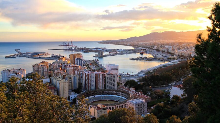Málaga port at sunset with the bullring and city