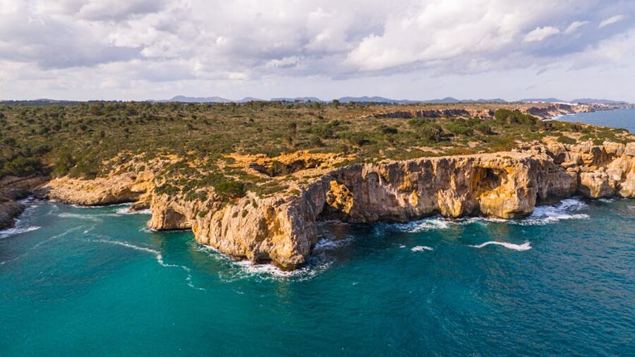 Aerial of Mallorca cliffs and turquoise sea on a sunny day