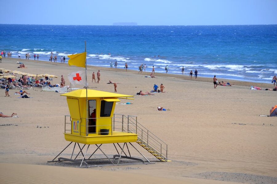 Maspalomas beach with yellow lifeguard tower and beachgoers
