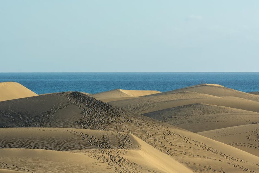 Rolling Maspalomas dune ridges with the blue sea beyond