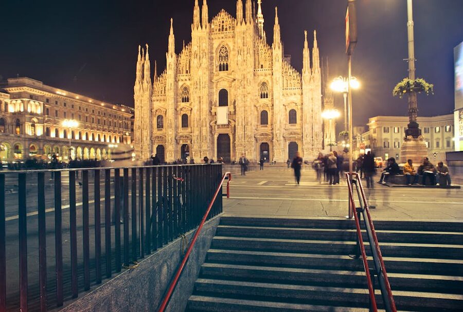Milan Duomo illuminated at night with crowd