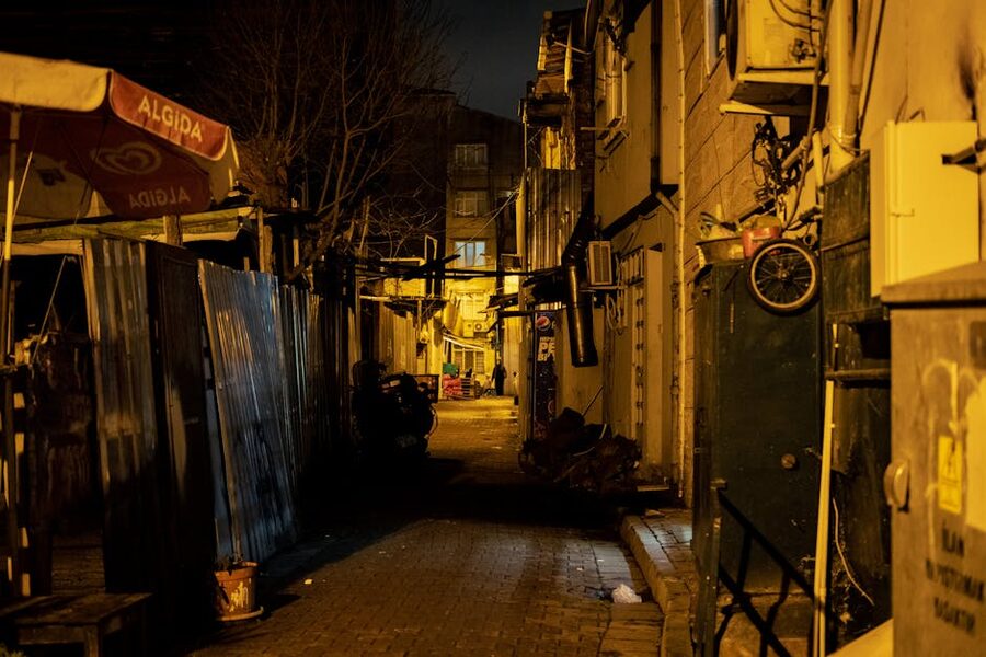 Moody narrow alley in Rome at night with warm streetlight
