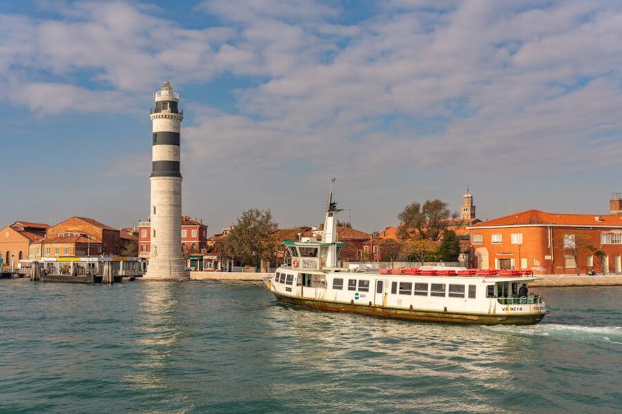 Murano lighthouse with ferry passing through Venetian lagoon