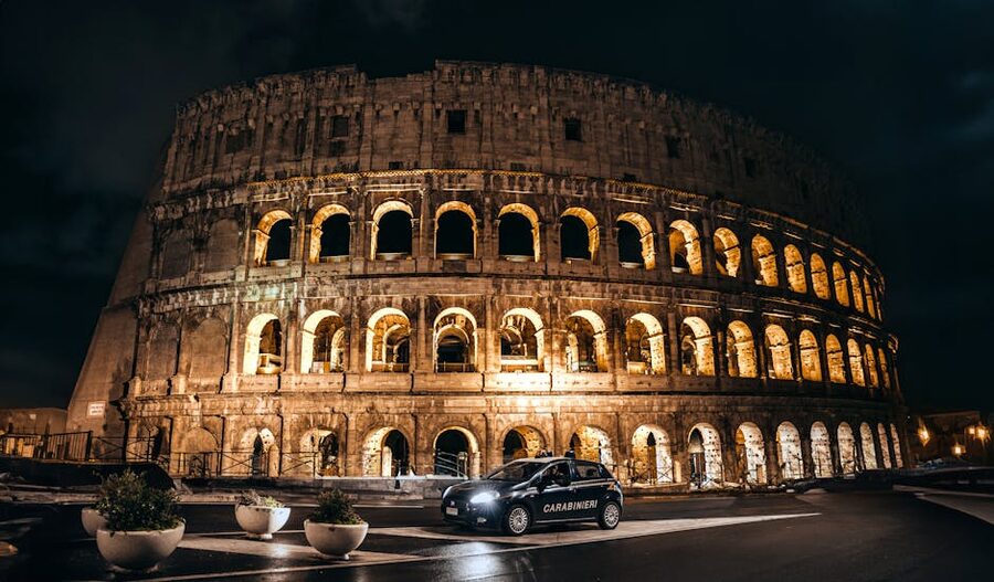 Illuminated Colosseum at night with an Italian police car