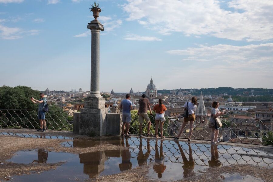 Tourists admiring panoramic view of historic Rome from a hilltop
