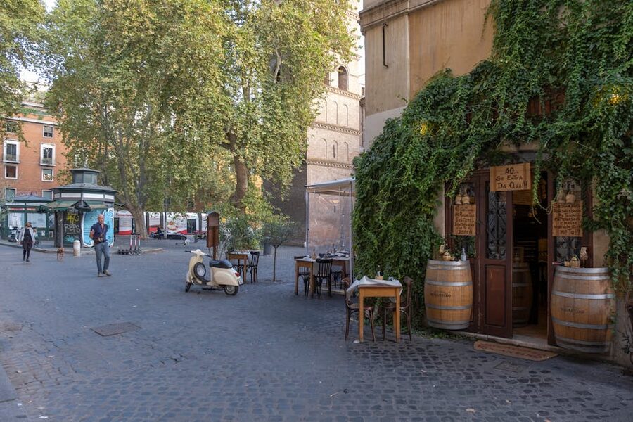 Rome street with ivy-covered cafe and parked scooter