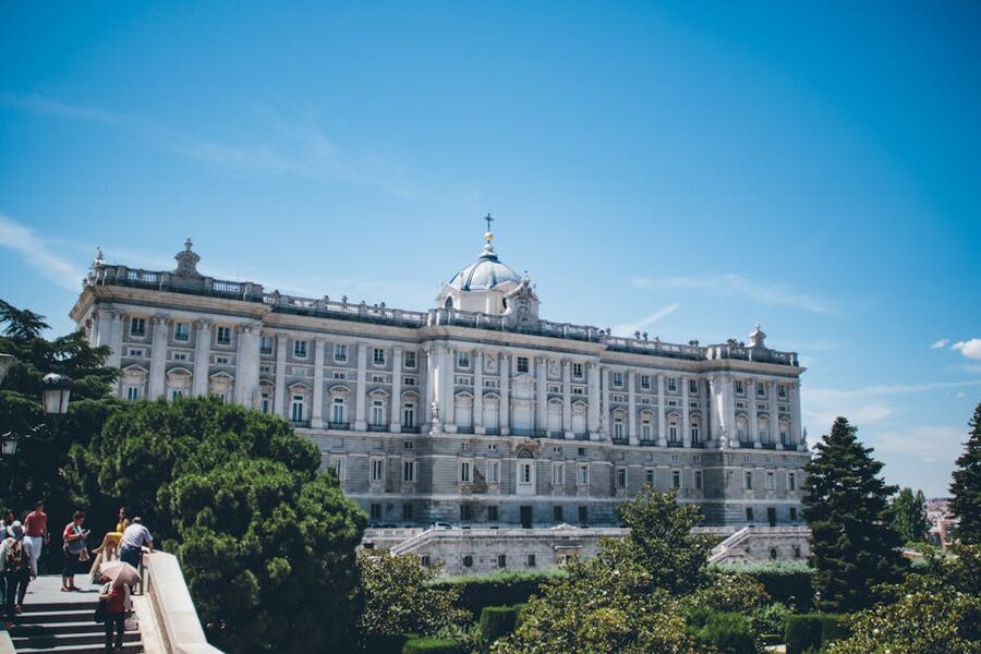Royal Palace Madrid seen from below with tourists in foreground