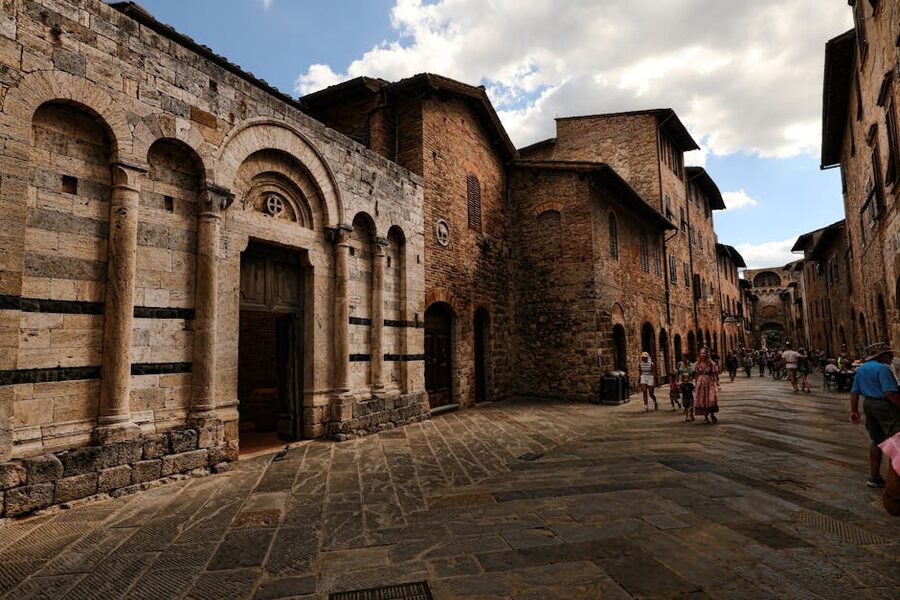 A medieval street in San Gimignano with stone buildings and shops