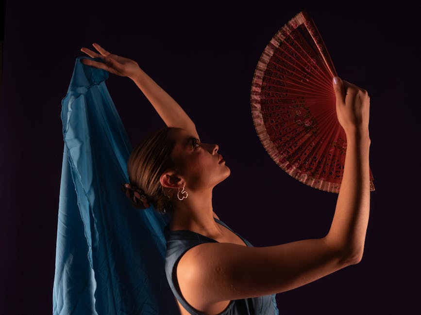 Flamenco dancer holding a traditional fan mid-performance