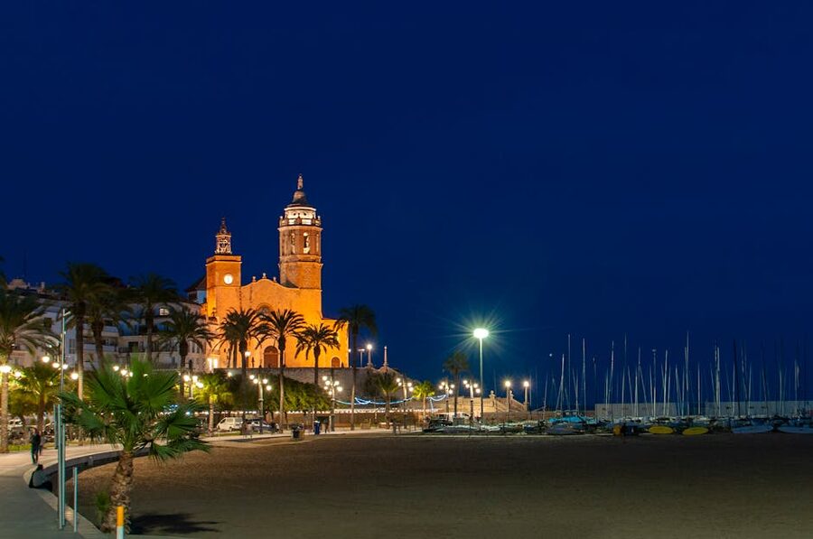 Sitges church illuminated at night above the promenade