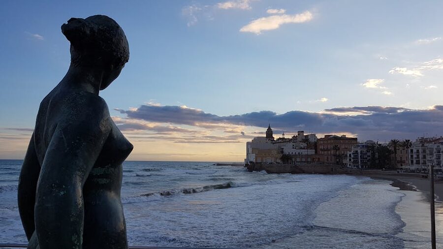 Sitges shoreline statue silhouetted at sunset